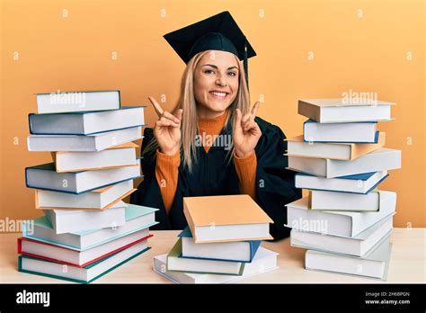 Mujer joven caucásica con un manto de ceremonia de graduación sentada