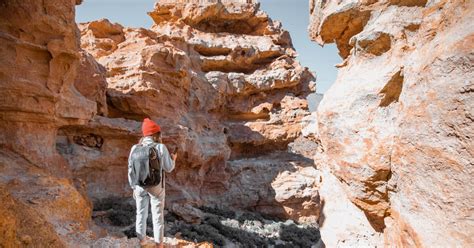화창한 날에 거대한 바위 화산 기원 사이에 서서 아름다운 풍경을 즐기는 여성 여행자 스페인 테네리페 섬 여행 사진 Unsplash의 마른 이미지