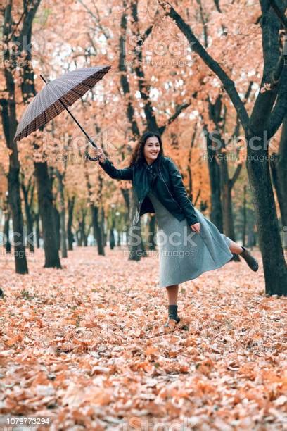 가 공원에서 포즈 우산 여자입니다 밝은 노란색 잎과 나무입니다 그녀는 바람을 Imitates 가을에 대한 스톡 사진 및 기타