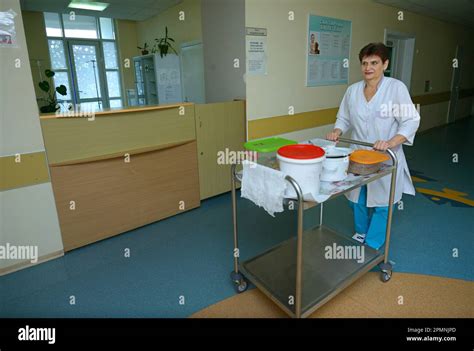 Krankenschwester In Einem Laborkittel Zieht Einen Tablettenwagen Mit