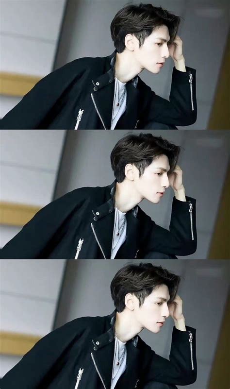 The Man Is Wearing A Black Jacket And Has His Hand On His Head While He