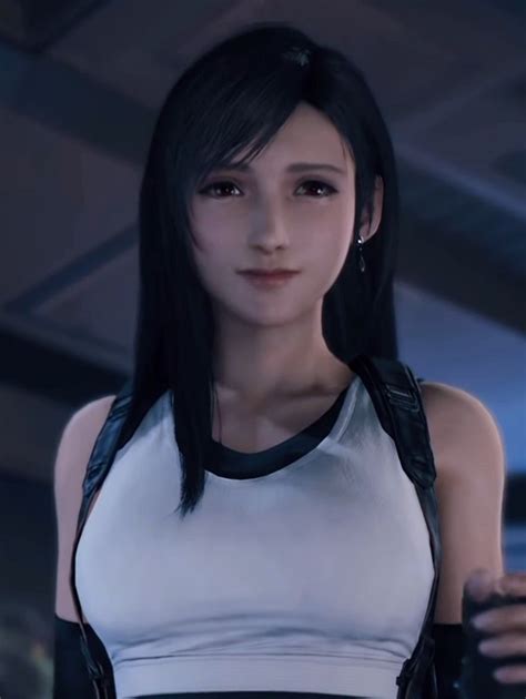 A Woman With Long Black Hair And White Top Standing In Front Of A