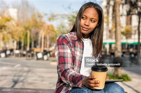 화창한 날에 테이크 아웃 커피를 들고 있는 동안 태블릿 Pc와 도시에서 야외 앉아 젊은 아름 다운 아프리카계 미국인 여자 갈색 머리에 대한 스톡 사진 및 기타 이미지