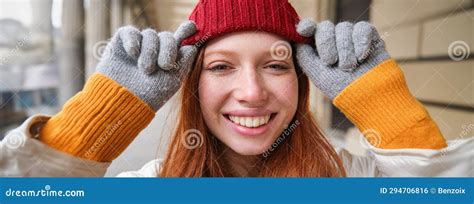Headshot Of Happy Redhead Girl With Freckles Wears Red Hat And Gloves