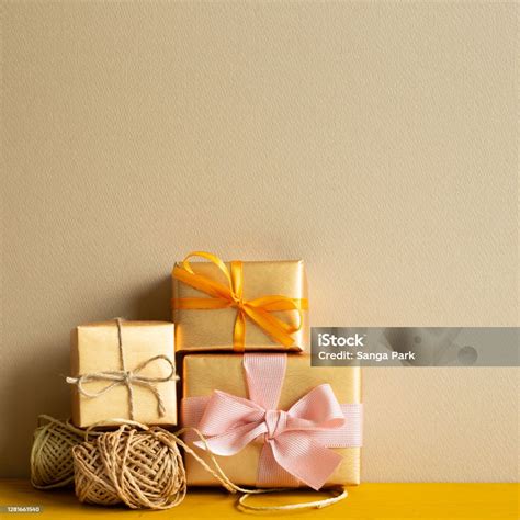 베이지 색 배경이있는 나무 테이블에 문자열 스레드 릴이있는 선물 상자 기념일 생일 크리스마스 컨셉 갈색에 대한 스톡 사진 및