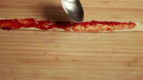 Spreading Tomato Paste On Puff Pastry With A Spoon Closeup Stock