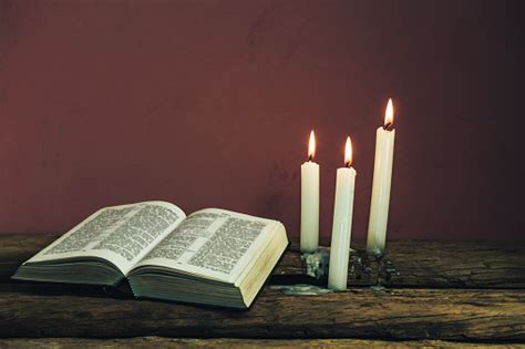 아름다운 오픈 성경과 오래된 오크 나무 테이블과 붉은 벽 배경에 세 개의 흰색 연소 촛불 교회에 대한 스톡 사진 및 기타 이미지