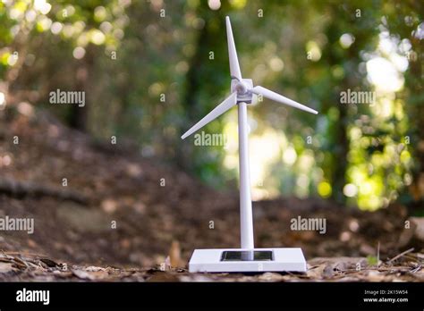 Portable White Solar Powered Windmill Toy Placed On Ground In Lush