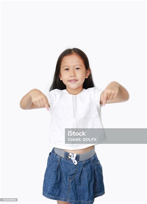 白い背景に笑顔の小さなアジアの子どもが下を向いて白い背景に何かを提示する教育のコンセプトにおけるアジアの女子高生 1人のストックフォトや