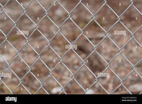 Rusty Chain Link Fence With A Brown And Grey Urban Background Blurred