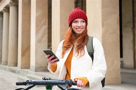 Redhead Girl Tourist With Backpack Uses Mobile Phone To Rent E