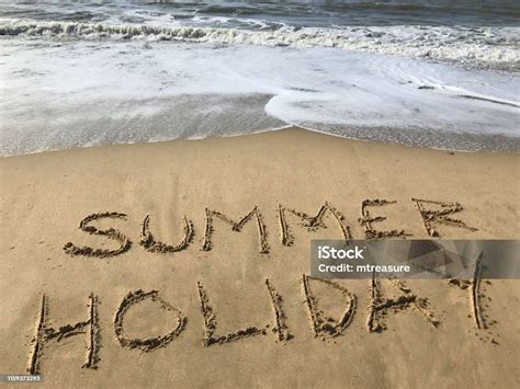 햇볕이 잘 드는 해변에서 여름 휴가 단어와 함께 모래에 쓰여진 글 바다 파도 본머스 해변의 부드러운 황금 빛 모래에 필기 편지의 개념 소셜 미디어 사진 도싯 영국 해변