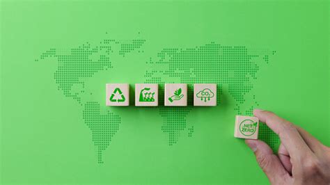 순 배출 제로 및 탄소 중립 2050 개념 손은 세계 지도 녹색 배경에 Net Zero 아이콘이 있는 나무 큐브 블록을 넣습니다