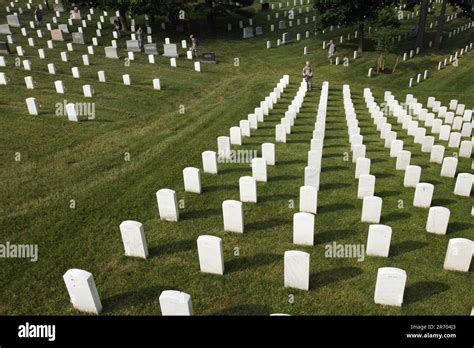 Soldiers Place Flags On Graves At Arlington National Cemetery Stock