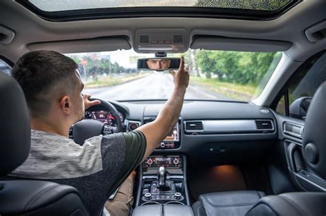 Premium Photo A Man Touching And Looking At Rearview Mirror