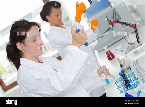 Female Scientists Using Pipettes In Lab Stock Photo Alamy