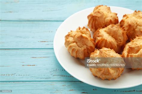 파란색 배경에 접시에 크림이 있는 수제 수익 창출 갓 구운 황금 프로피테롤 갈색에 대한 스톡 사진 및 기타 이미지 갈색