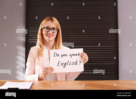 Teacher Holding Sheet Of Paper With Words Do You Know English In Class