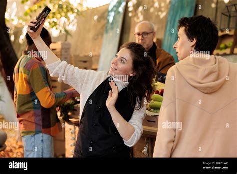 Happy Woman Farmer Holding Mobile Phone Making Photo With Customer