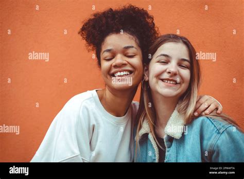 Portrait Of Two Happy Joyful Teen Girls Of Different Races Smiling At