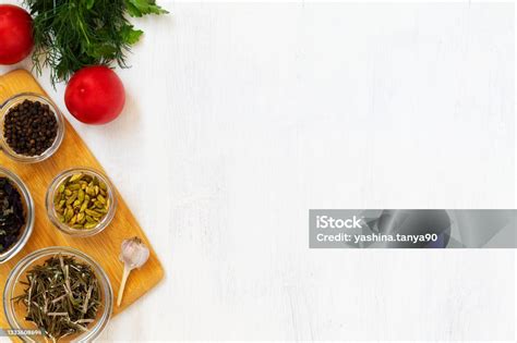 야채와 향신료도마에서 요리하기위한 건조 향신료 흰색 테이블에 음식 재료 녹색 허브 향신료 토마토와 복사 공간을 갖춘 평평한 평지