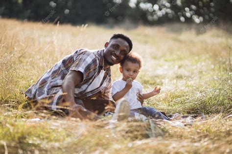 Padre Africano Abrazando A Un Hijo Pequeño Durante Un Picnic En La Naturaleza Foto Premium