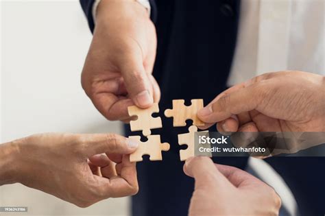 팀워크와 파트너십의 개념 사무실에서 퍼즐 조각을 맞추는 사업가의 손과 직소 퍼즐 팀으로 모입니다 자선 자원 봉사자 팀으로서의