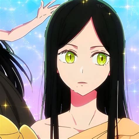 A Woman With Long Black Hair And Green Eyes Standing In Front Of A Blue Sky