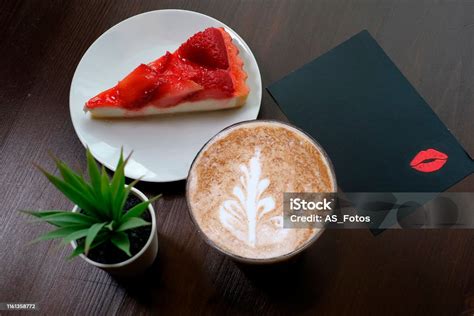 나무 테이블에 커피 한 잔 맛있는 딸기 케이크 조각 나뭇잎 검은 색과 키스 비문에 대한 장소 커피 거품에 아름다운 패턴 공란에