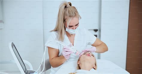 환자의 피부 탄력을 개선하기 위한 미용 절차를 수행하는 의료용 마스크에 집중된 미용사 사진 Unsplash의 아름다움 이미지