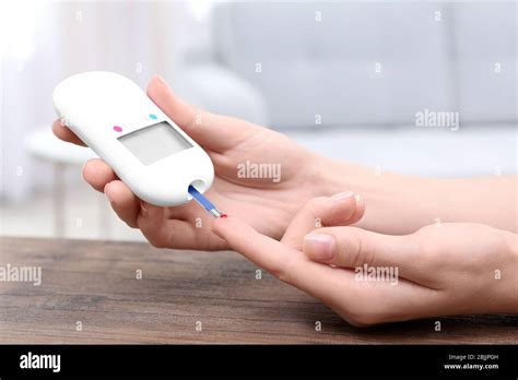Woman Testing Glucose Level With Digital Glucometer Indoors Stock Photo Alamy