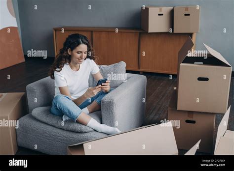 Lächelndes Mädchen Das Online Einen Mover Auswählt Mit Der Handy App Sitzt Mit Pappkartons