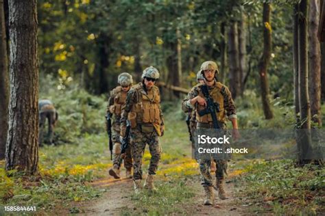 현대전 군인 그룹이 위험한 외딴 산림 지역에서 전쟁을 벌이고 있습니다 한 무리의 군인들이 현대 무기로 적진에서 싸우고 있습니다 전쟁과 군사 분쟁의 개념 군대에 대한 스톡