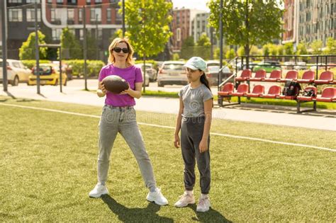 Young Mother With Daughter Playing Soccer Outdoor Portrait Stock