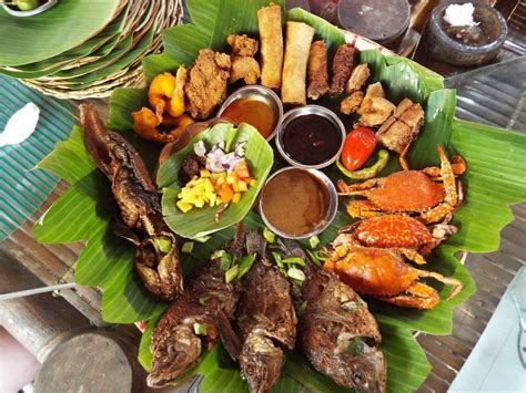 A Platter Filled With Different Types Of Food On Top Of Leafy Green Leaves