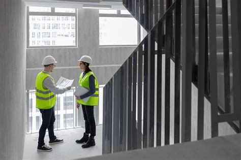 흰색 헬멧과 녹색 보호 조끼를 입은 두 명의 엔지니어 한 남자와 한 여자 2명에 대한 스톡 사진 및 기타 이미지 2명 가리키기 개발 Istock