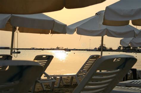 Beatiful Shot Of A Bay Through Beach Chairs And Umbrellas At Sunset