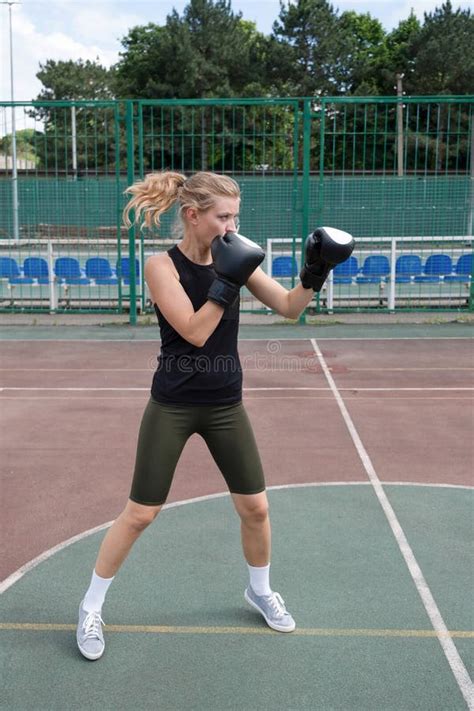Young Female Boxer Training In The Stadium Standing In Position Stock