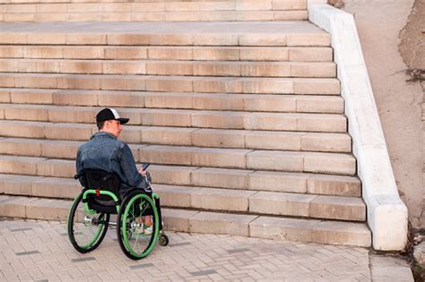 휠체어를 탄 젊은 장애인은 계단을 들어갈 수 없습니다 장애인을 위한 접근 가능한 환경 거리에 대한 스톡 사진 및 기타 이미지