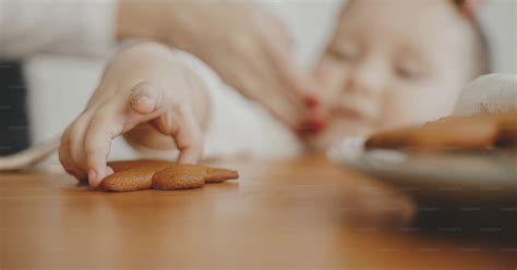 귀여운 어린 소녀가 나무 테이블에 갓 구운 진저브레드 쿠키를 들고 있다 정통 사랑스러운 순간 휴가 준비 어머니와 함께