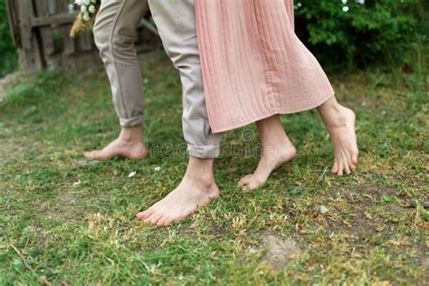Young Loving Couple Hugging And Dancing On The Green Grass On The Lawn