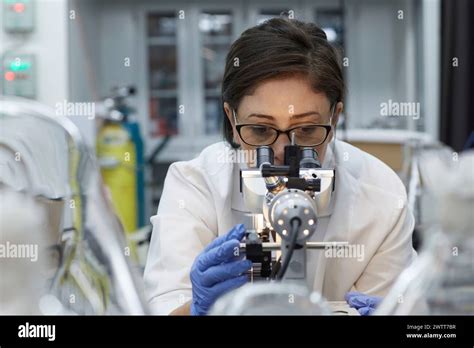 Attractive Female Scientist Testing Using Microscope To Test For Dna