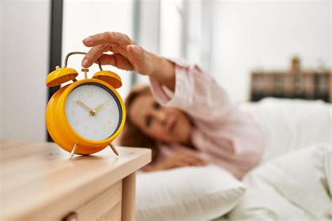 Premium Photo Middle Age Caucasian Woman Turning Off Alarm Clock