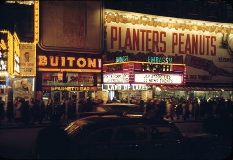 Embassy Theater Showing Newsreel Format Films At Night With Neon Signs