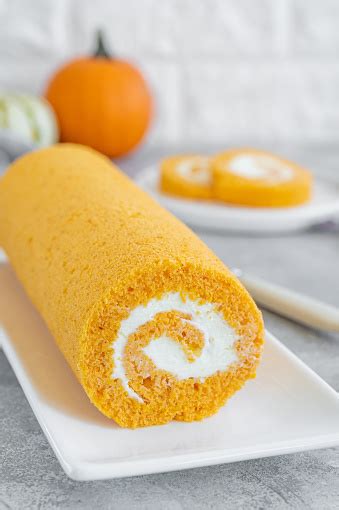 회색 콘크리트 배경에 크림 치즈를 채우는 호박 케이크 롤 추수 감사절 이나 할로윈 디저트 선택적 초점 복사 공간 스위스 롤에