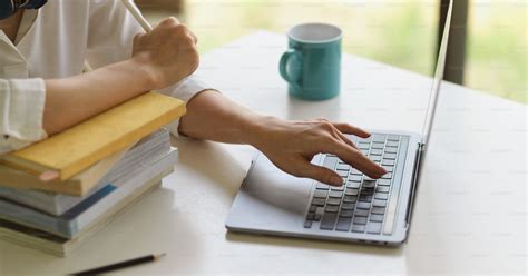 집에서 거실에서 노트북과 책 더미로 온라인으로 공부하는 여대생의 측면 모습 사진 Unsplash의 사무실 책상 이미지