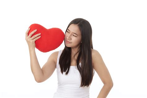 여자 갈색 머리 긴 머리 입고 A 흰색 탱크 탑 들고 빨간 심장 사랑 기호 스튜디오 샷 에 흰색 배경 25 29세에 대한 스톡