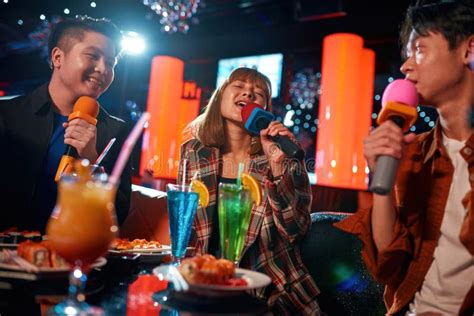 Young Asian People Having Fun While Singing Karaoke On Night Party At