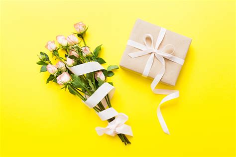 분홍색 장미 꽃과 선물 상자가 컬러 테이블 배경 위에 있는 디자인 컨셉 해피 홀리데이 어머니의 날 생일 개념 낭만적 인 플랫