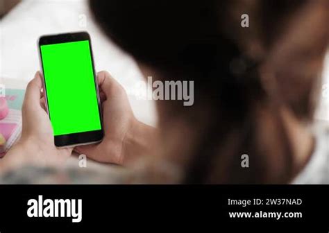 Woman Looks At Green Screen Of Mobile Phone And Talks On Online Video